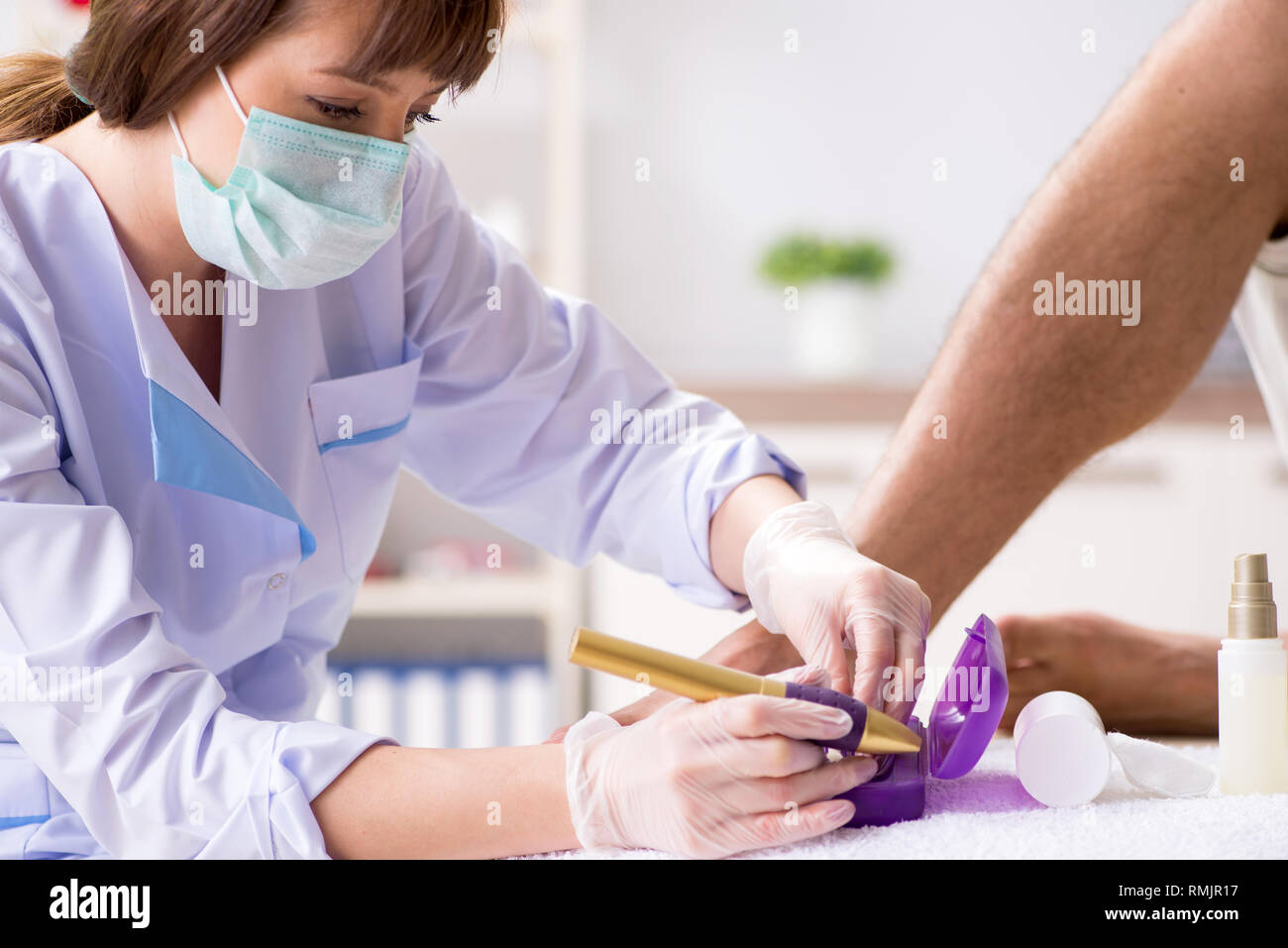 Podiatrist treating feet during procedure Stock Photo - Alamy