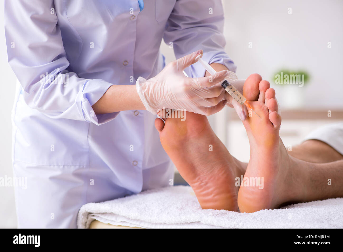 Podiatrist treating feet during procedure Stock Photo - Alamy