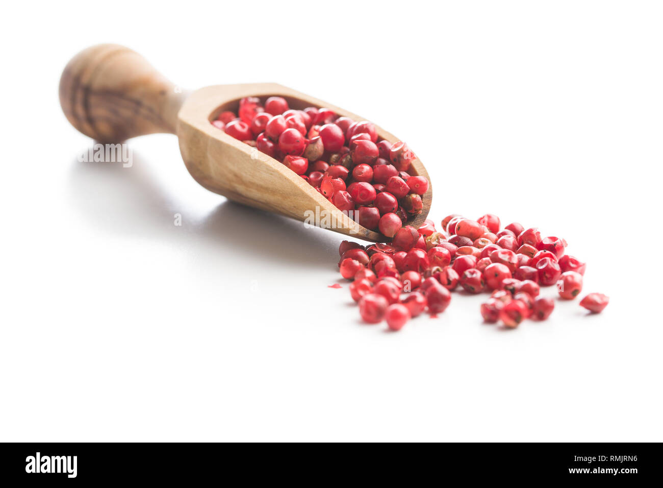 Dried pink peppercorn in wooden scoop isolated on white background ...