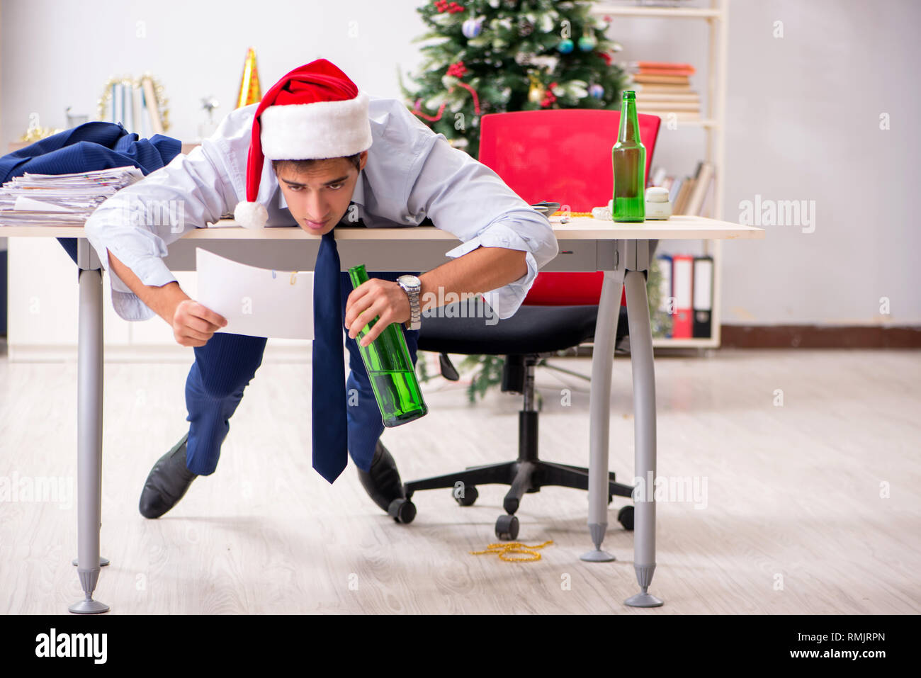 Young handsome employee celebrating Christmas at workplace Stock Photo ...