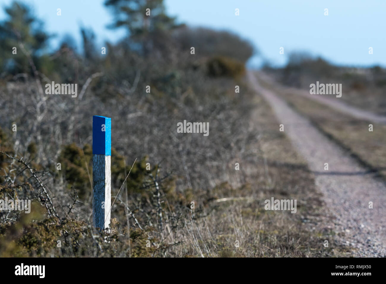 Wooden way marker by an unfocused country road Stock Photo - Alamy