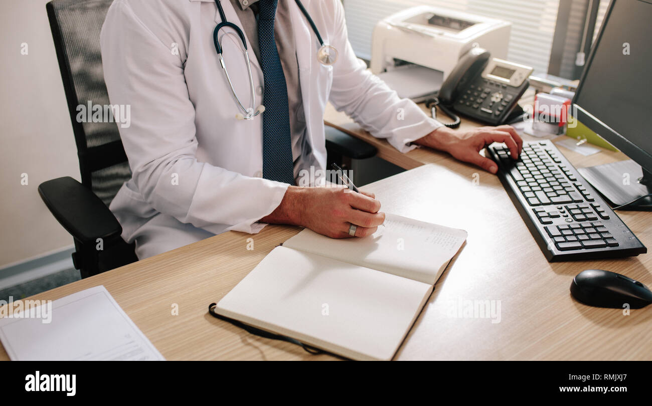 Hands of male doctor searching new information on medication using ...