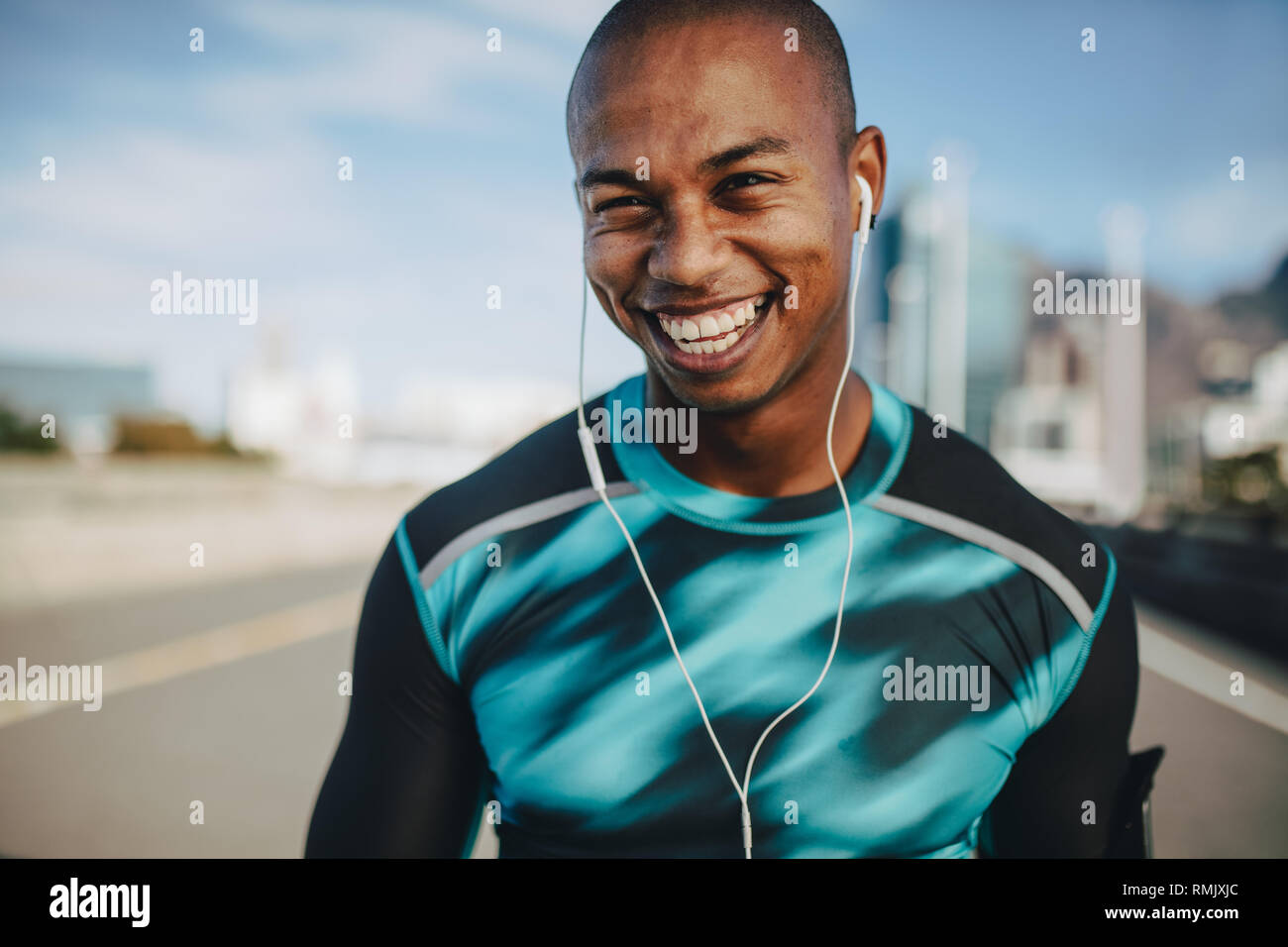 Fit young male runner with a broad smile. Young man in sports shirt and ...