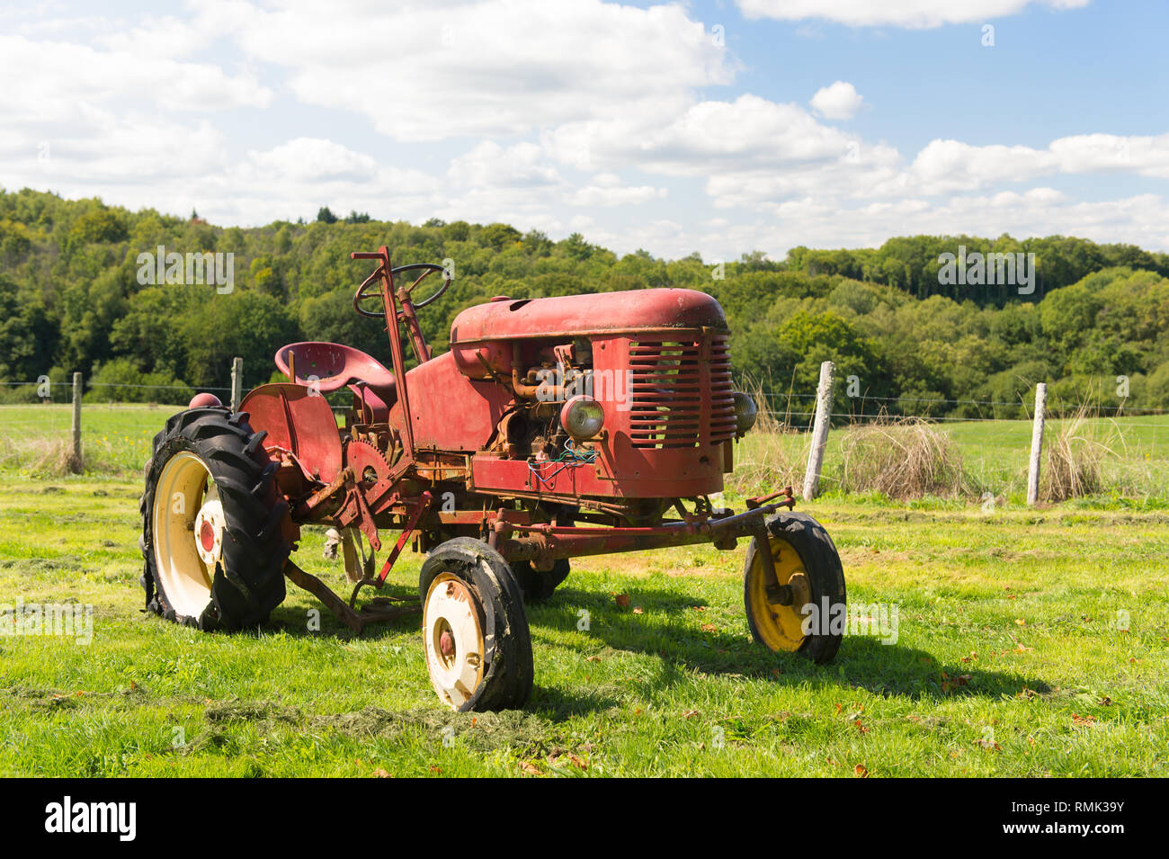Old rusty vintage red tractor in agriculture landscape Stock Photo - Alamy