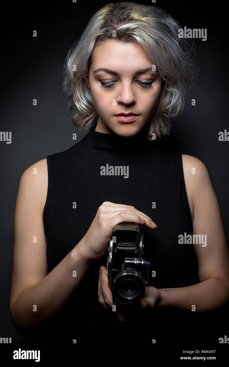Female actor posing with a vintage camera as an artistic director ...