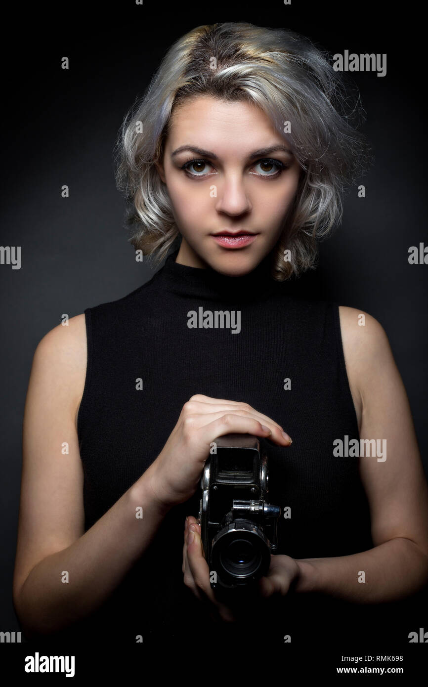Female actor posing with a vintage camera as an artistic director ...