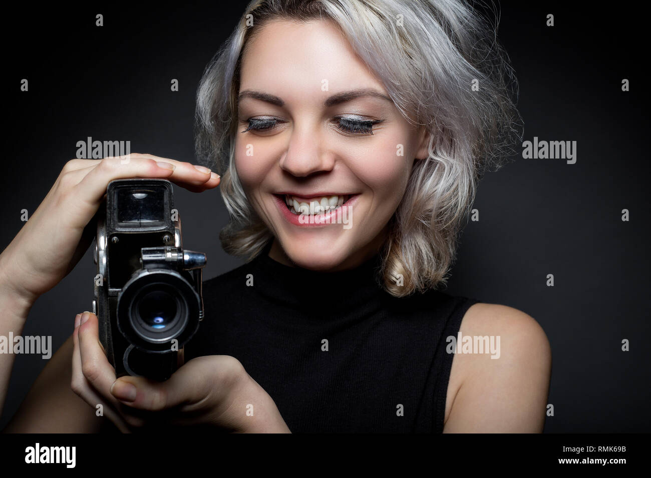 Female actor posing with a vintage camera as an artistic director ...