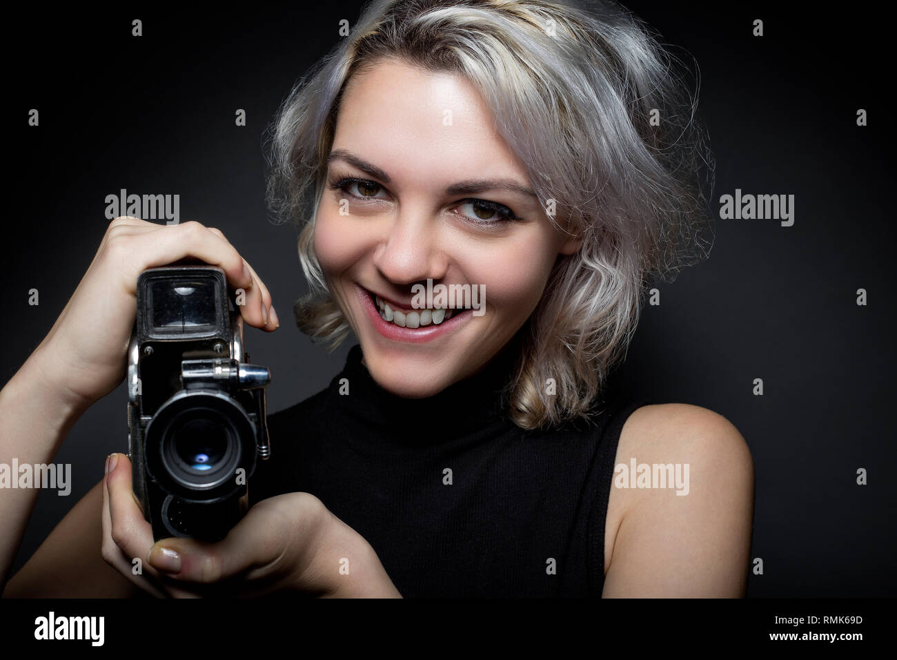 Female actor posing with a vintage camera as an artistic director ...