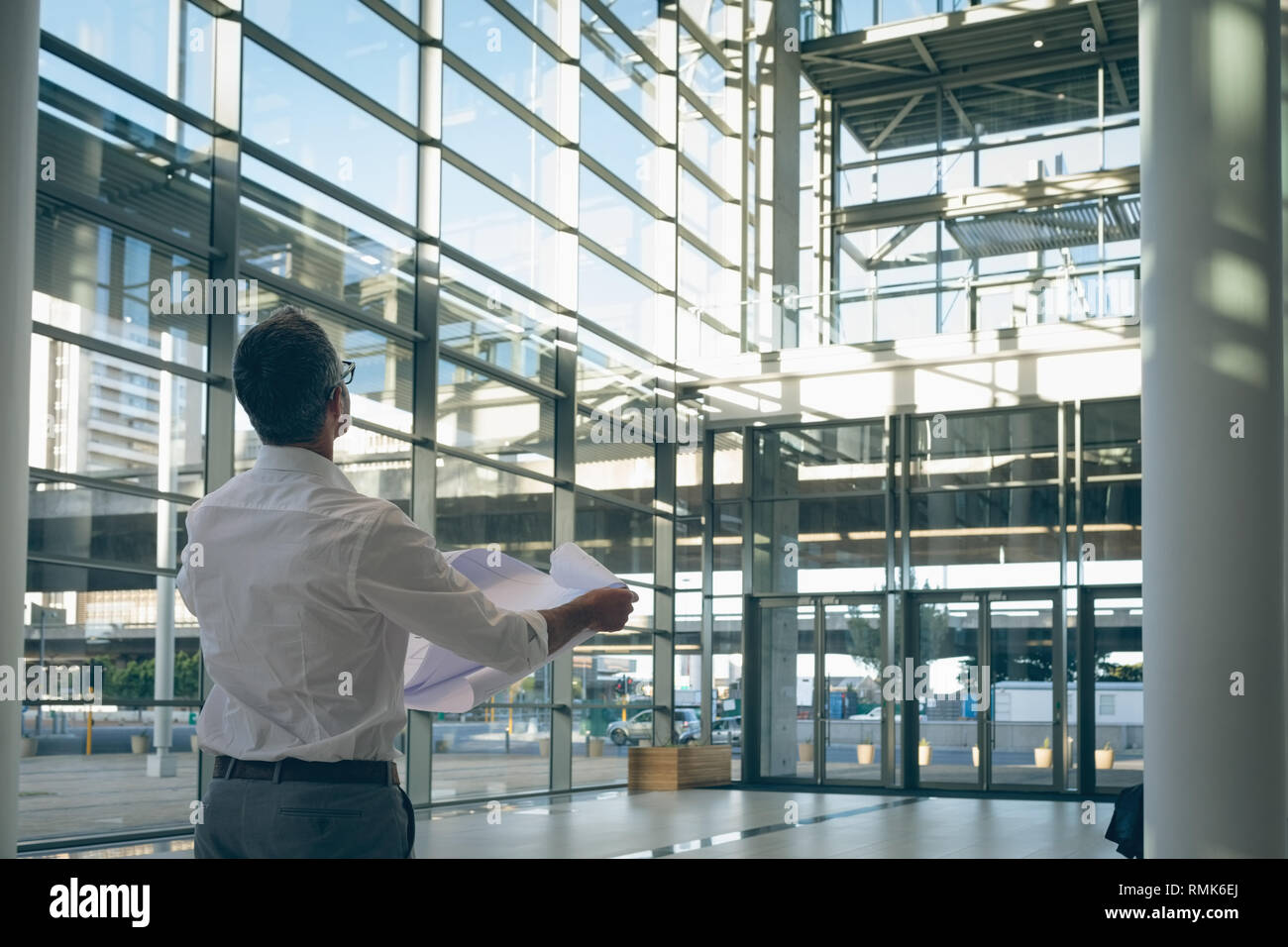 Businessman reading a blueprint plan in office Stock Photo - Alamy