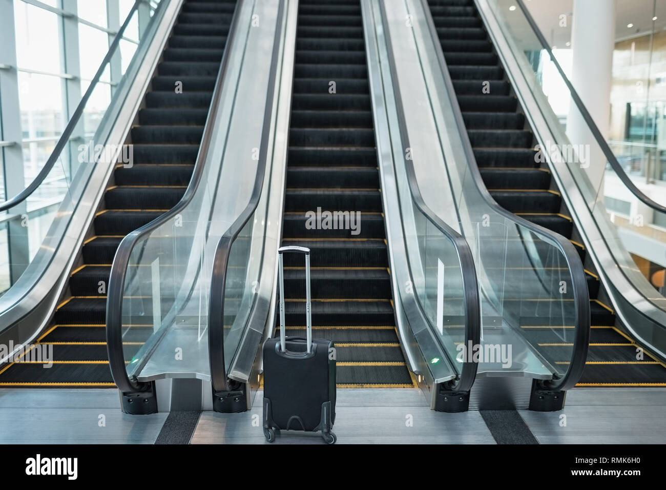 Three escalators side by side and suitcase in the office Stock Photo ...