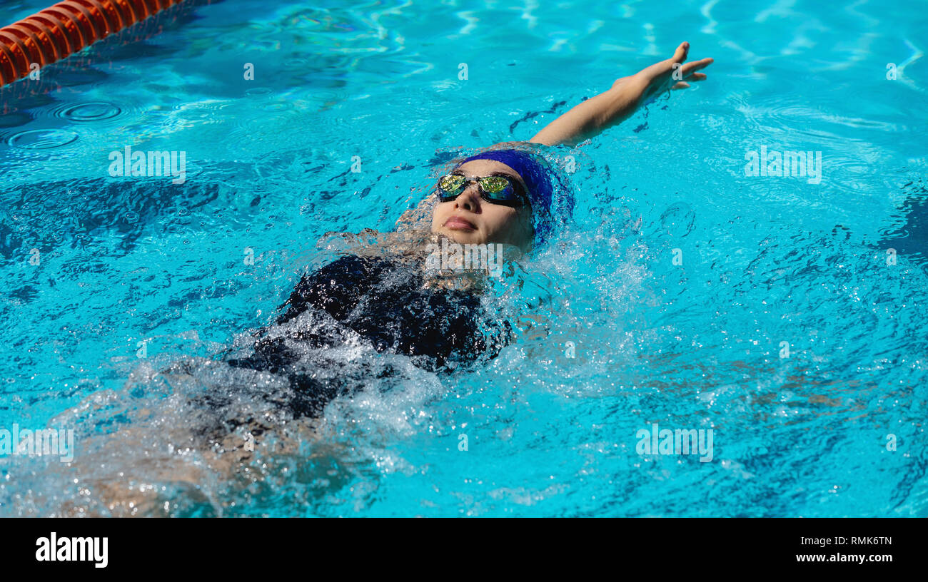 Female swimmer swimming backstroke in swimming pool Stock Photo - Alamy