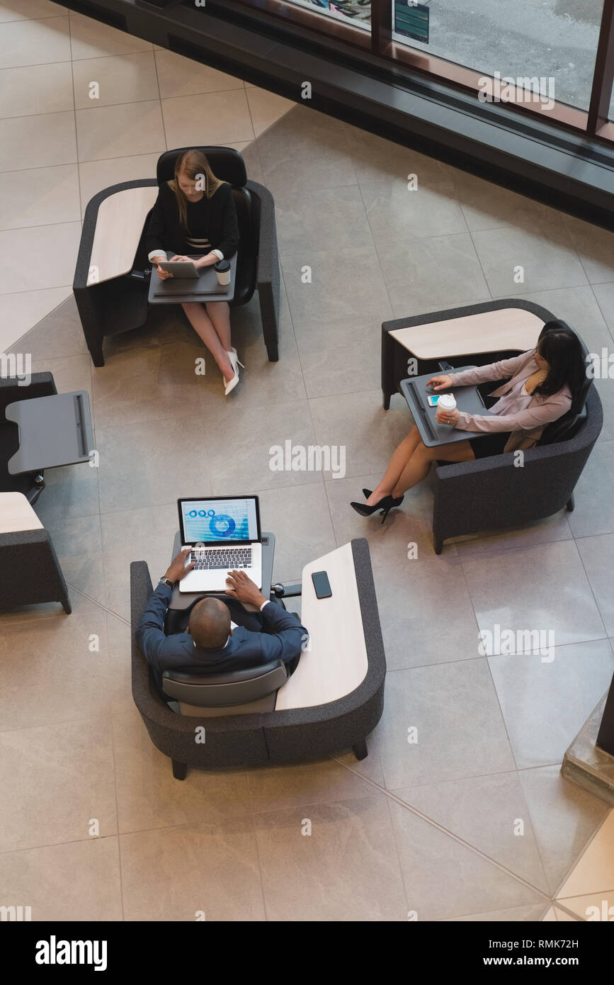 People using multimedia devices in the lobby Stock Photo - Alamy