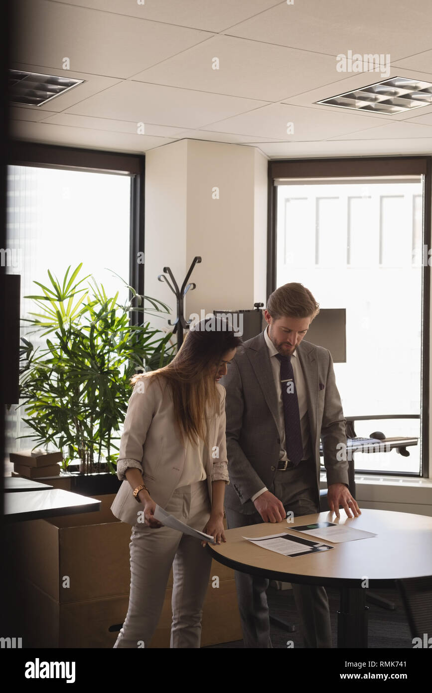 People discussing over documents in the office Stock Photo - Alamy