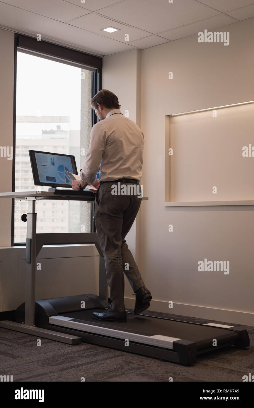 Man working while exercising on treadmill Stock Photo - Alamy
