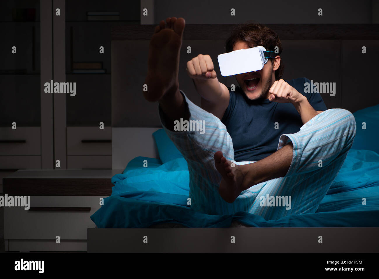 Young man playing computer games at night in bed Stock Photo - Alamy