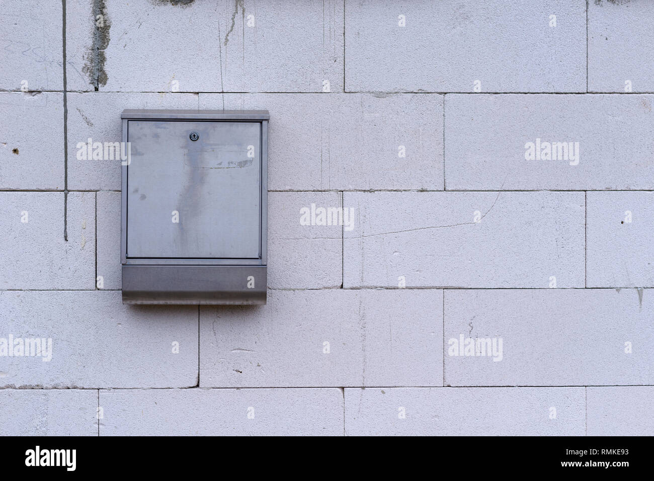 Postbox on a cement block exterior wall in a close up view Stock Photo ...