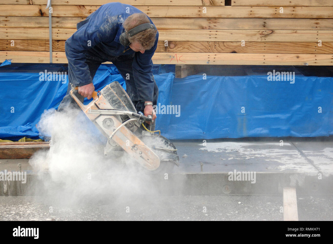 Builder cuts edge of concrete slab with diamond saw blade concrete ...