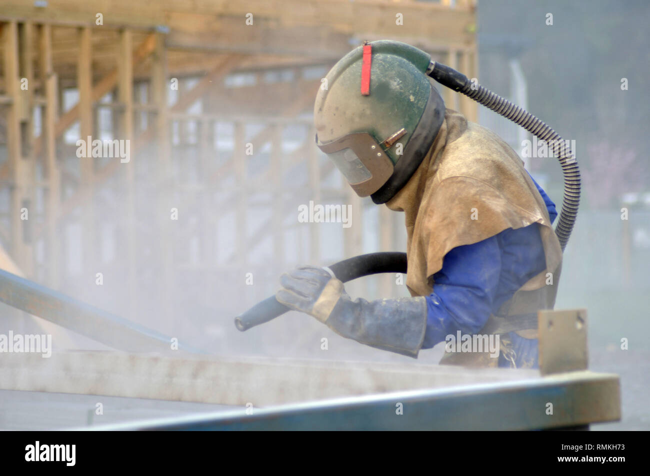 tradesman sandblasting beams for building project Stock Photo - Alamy