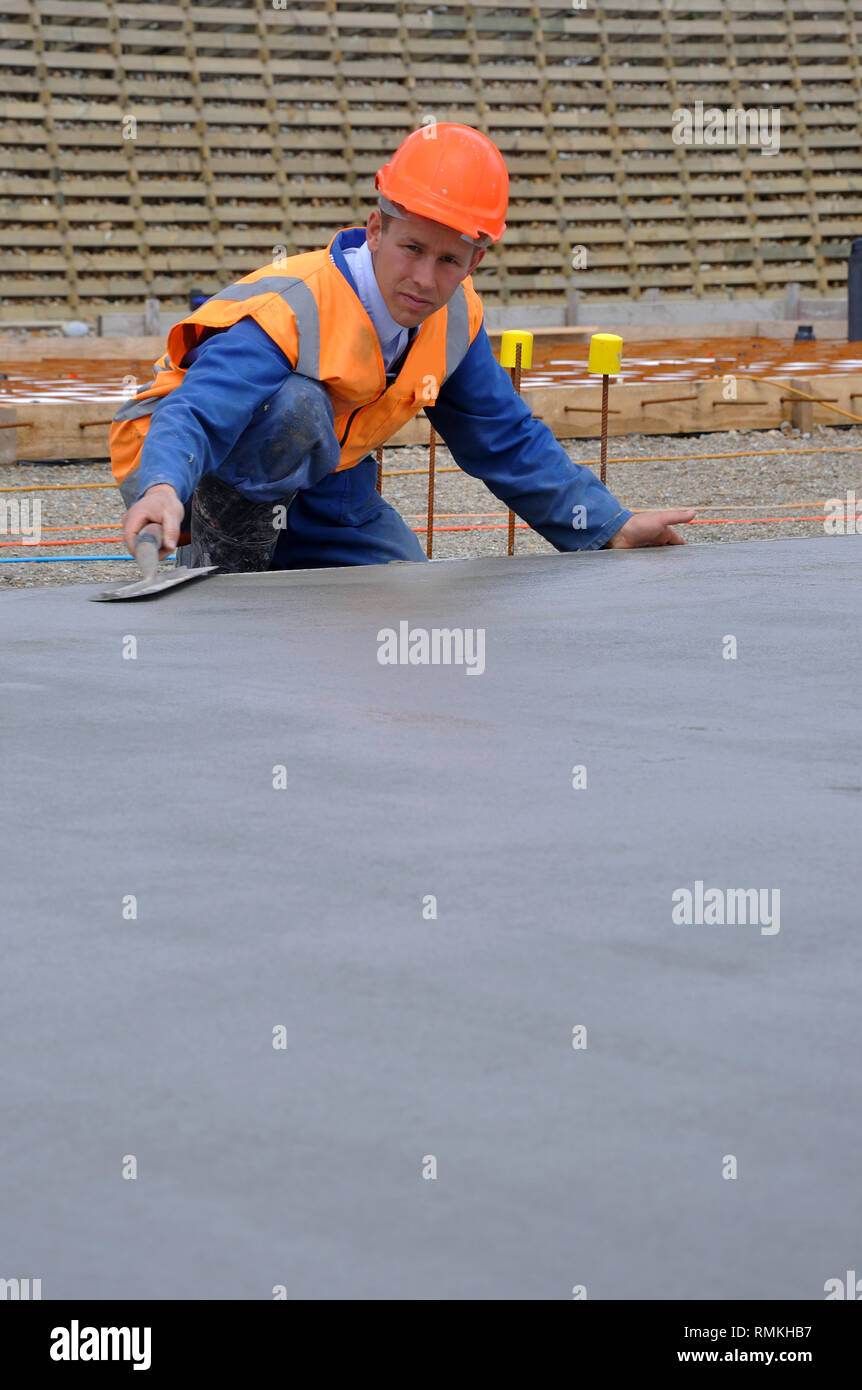 Builder floating wet concrete in foundations of a large building Stock ...