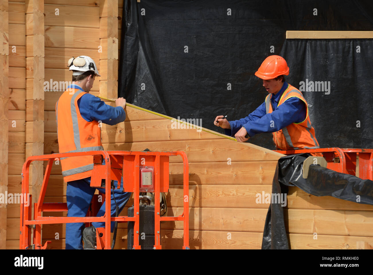 builders measure the wall of a lockwood style building Stock Photo - Alamy