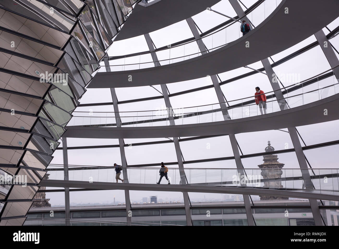 People ascend the Reichstag dome in Berlin, Germany on an overcast day ...