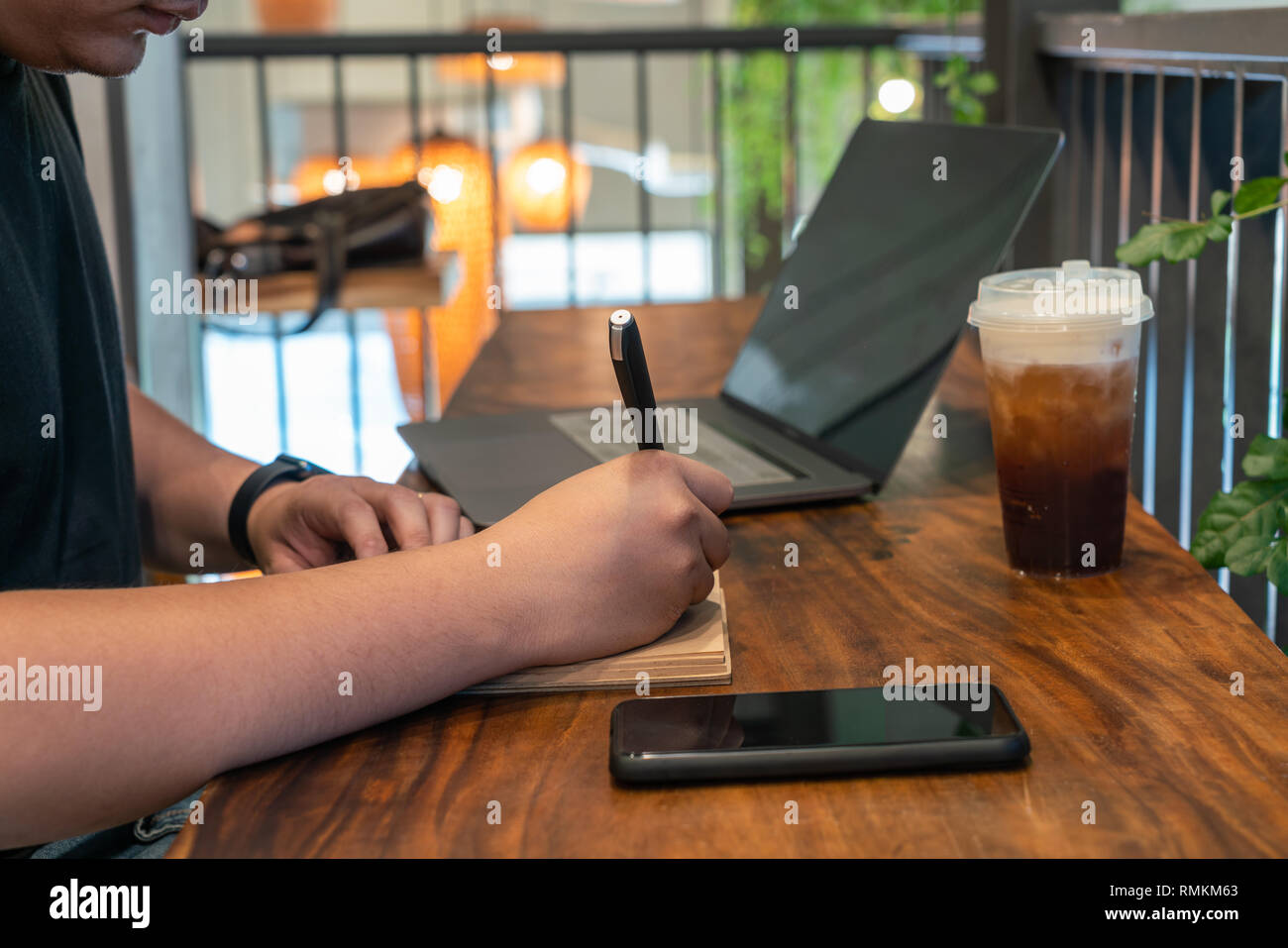 Young man writing into notes Stock Photo - Alamy