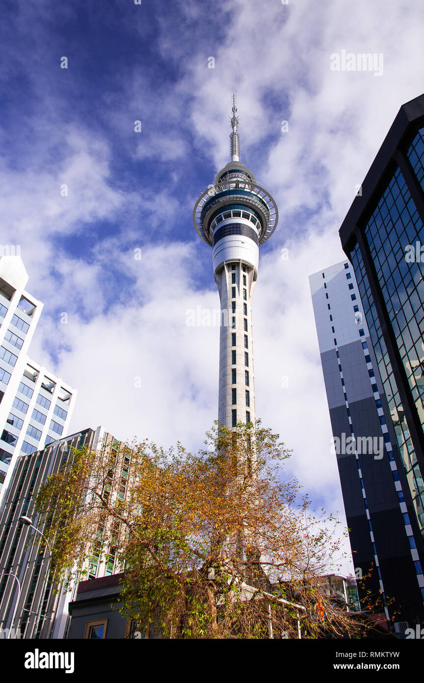 Auckland's Sky Tower, silhouetted against a blue cloudy sky. A major ...