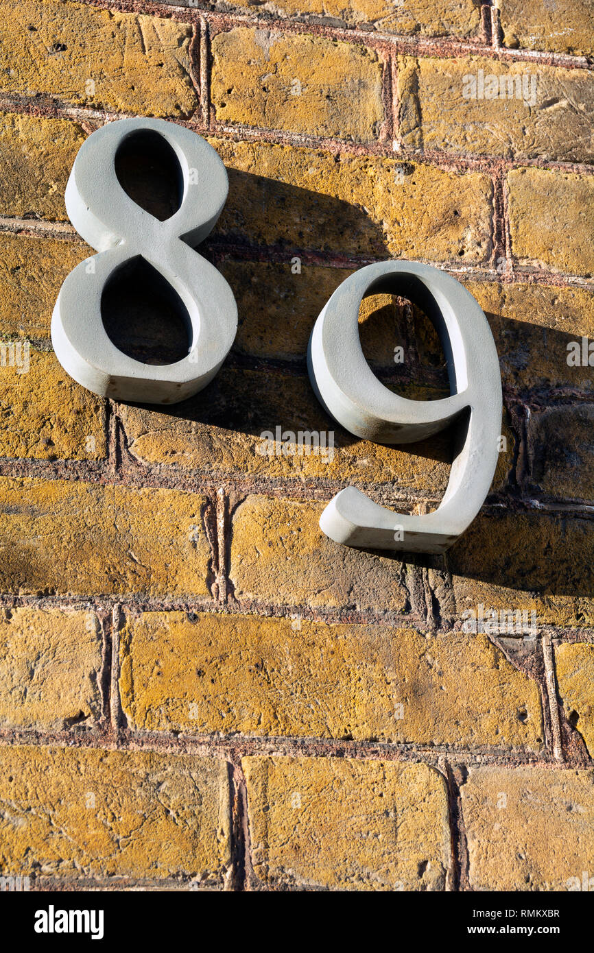 Number eighty nine on exterior wall in strong sunshine Stock Photo - Alamy
