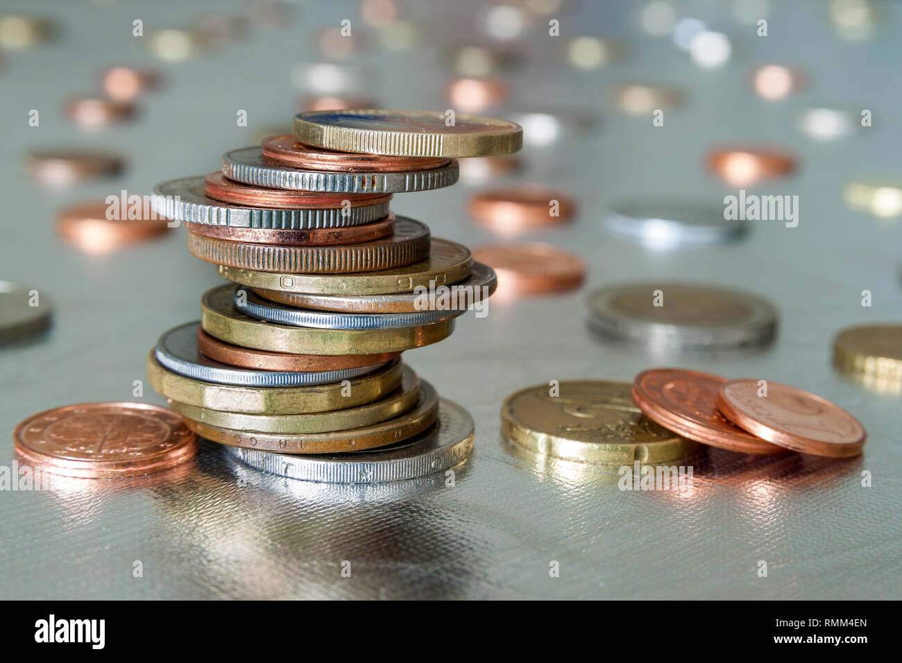 Pile of shiny coins different sizes and colors stacked unevenly on each ...
