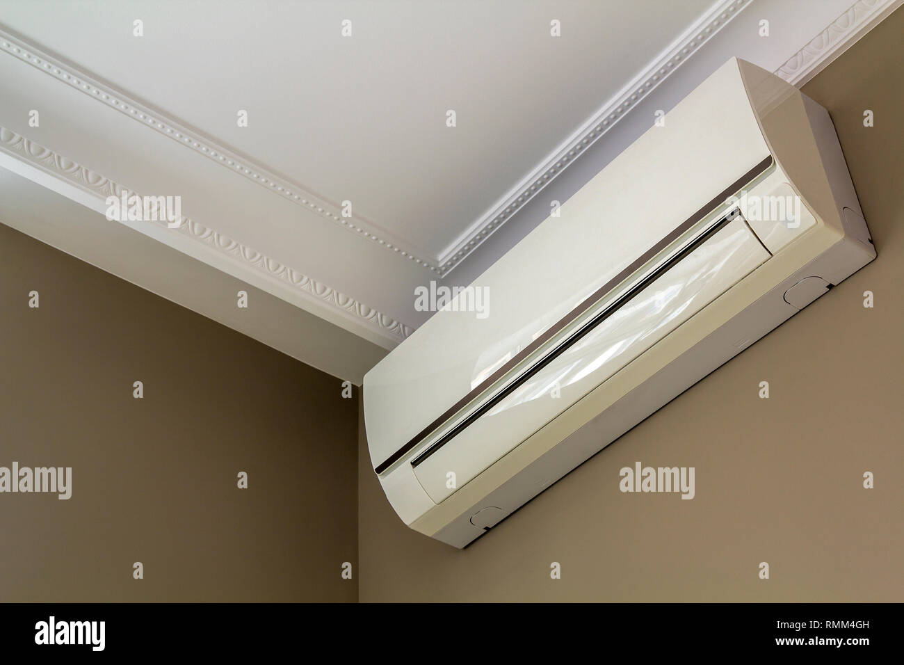 Cool air conditioner installed in room interior on white ceiling and ...