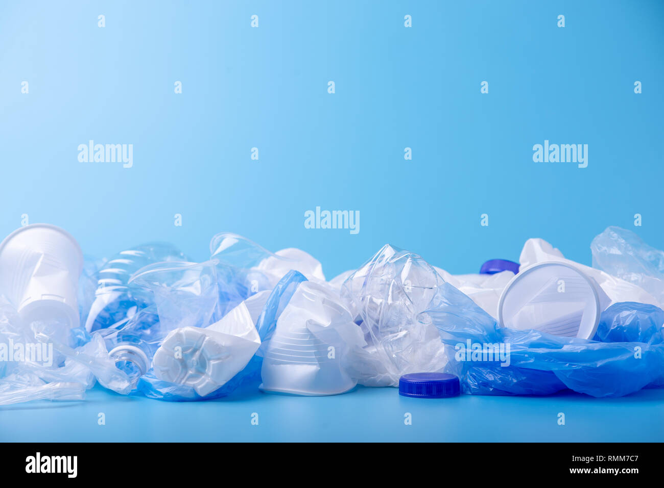 Used clean plastic garbage in a pile. Bottles and bags on blue ...