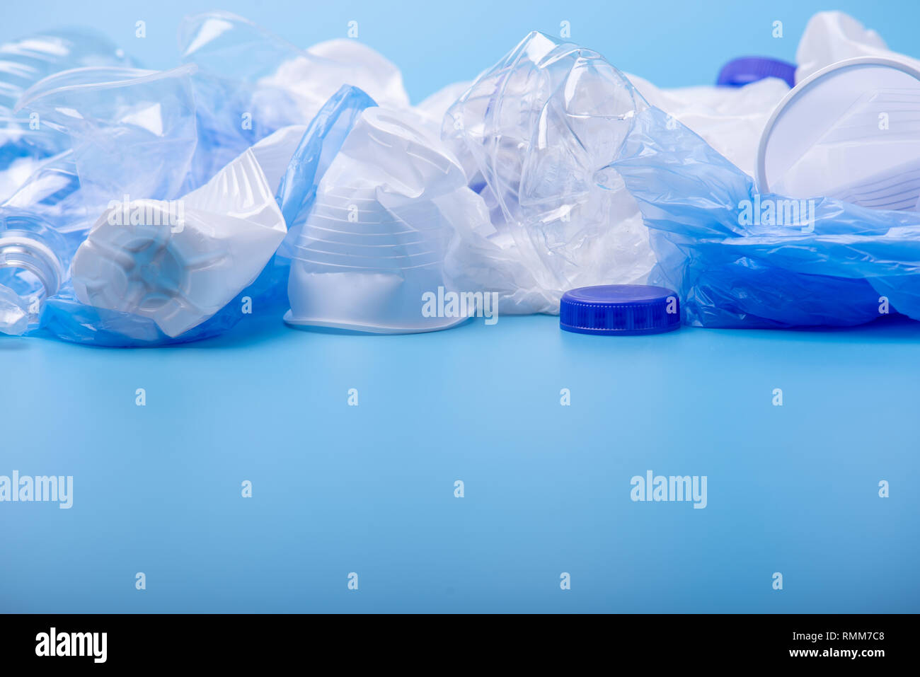 Used clean plastic garbage in a pile. Bottles and bags on blue ...