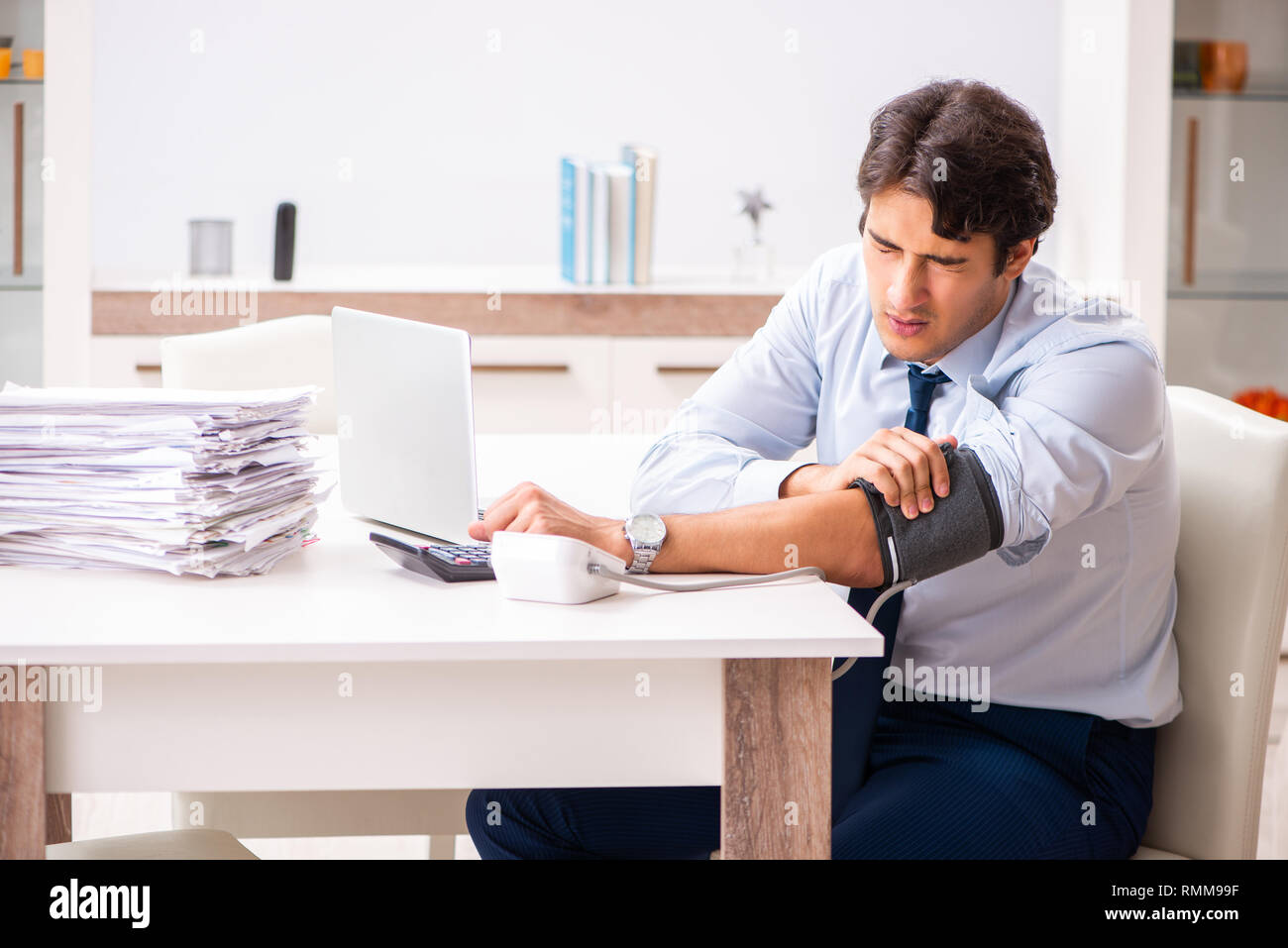 Man under stress measuring his blood pressure Stock Photo - Alamy