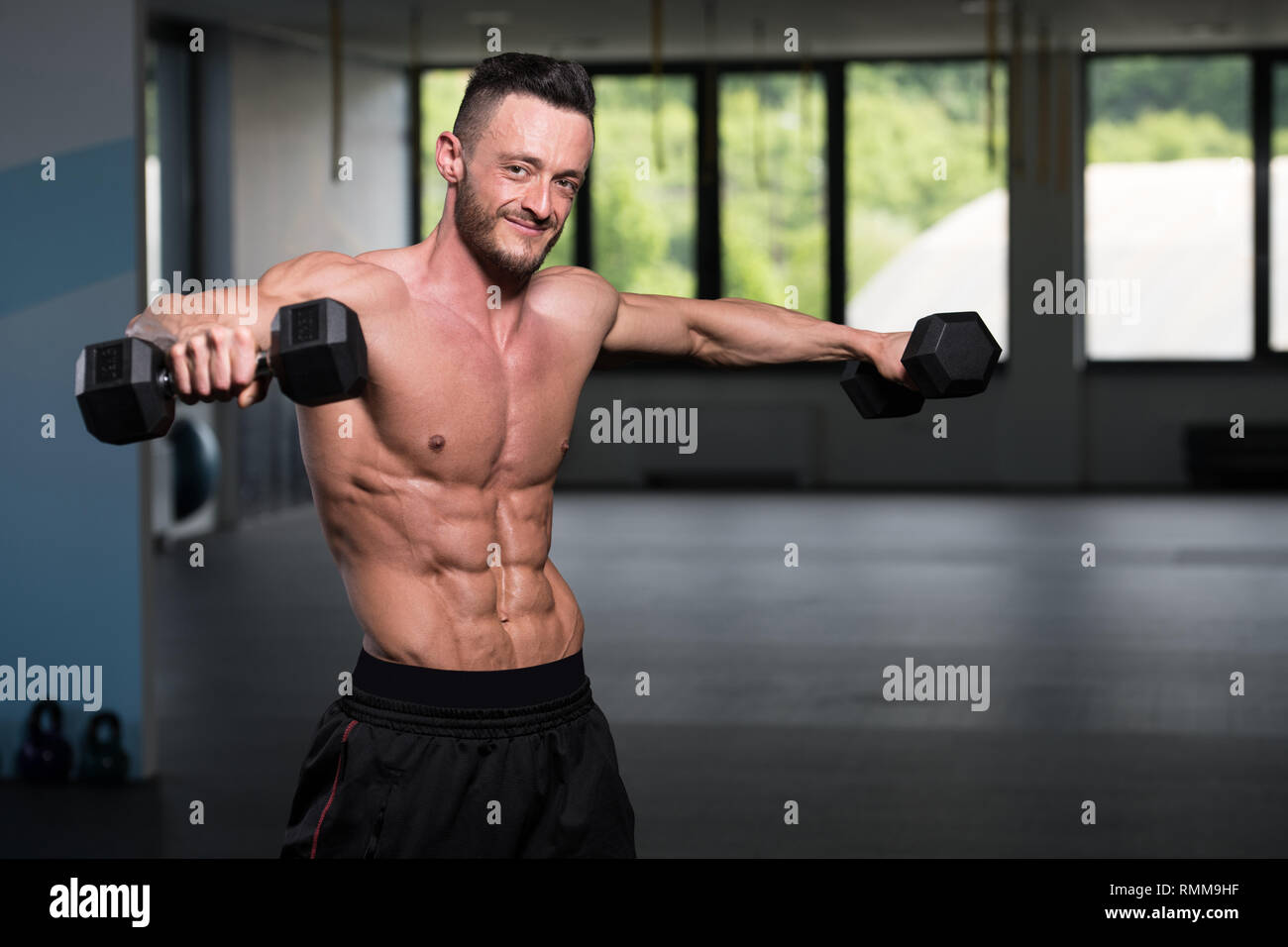 Athlete Working Out Shoulders In A Gym - Dumbbell Concentration Curls ...