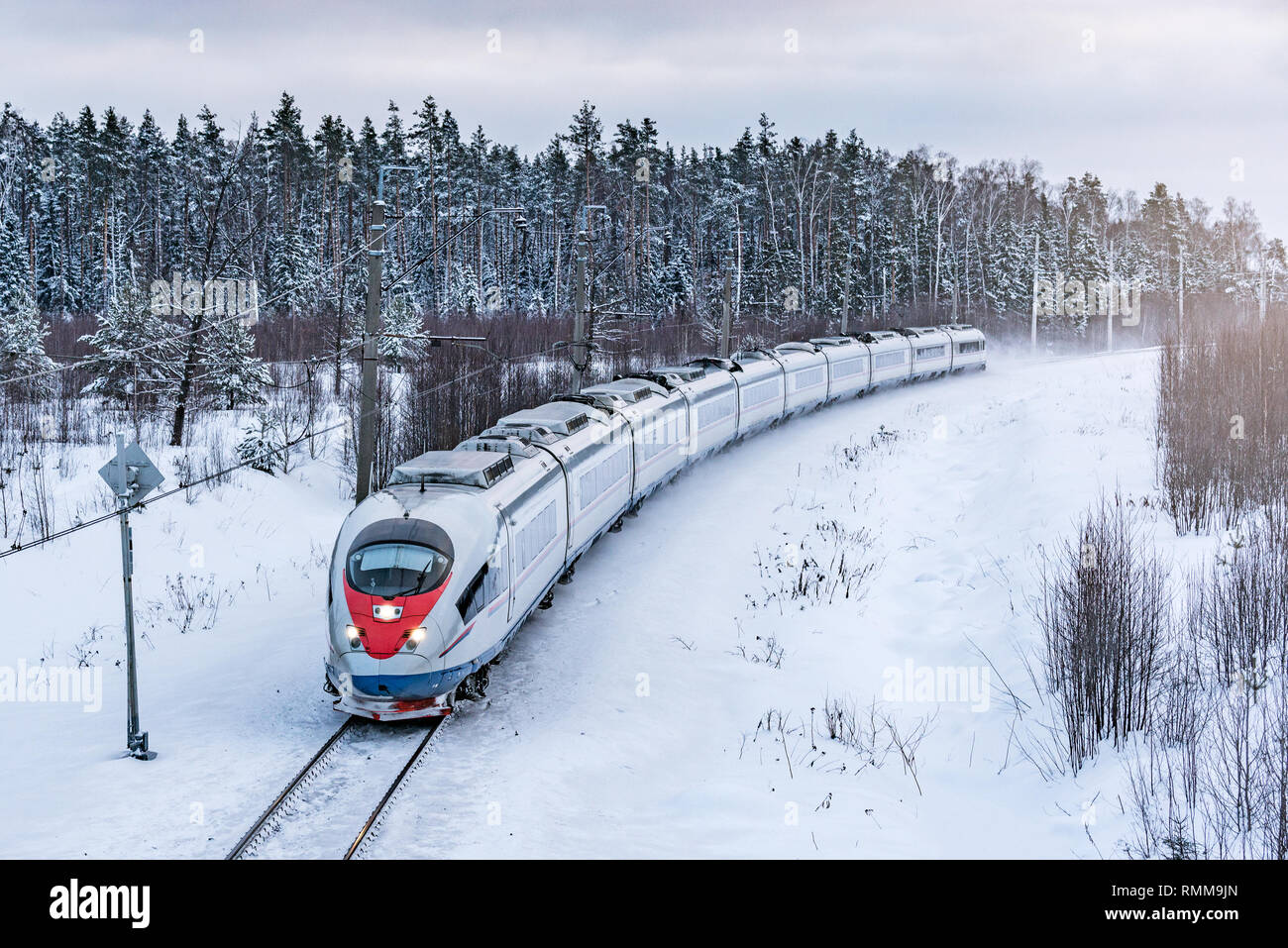 Modern high-speed train approaches to the station at winter morning ...