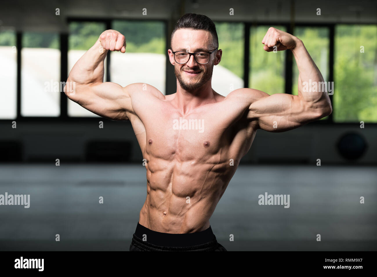 Portrait Of A Young Physically Fit Nerd Man Showing His Well Trained ...