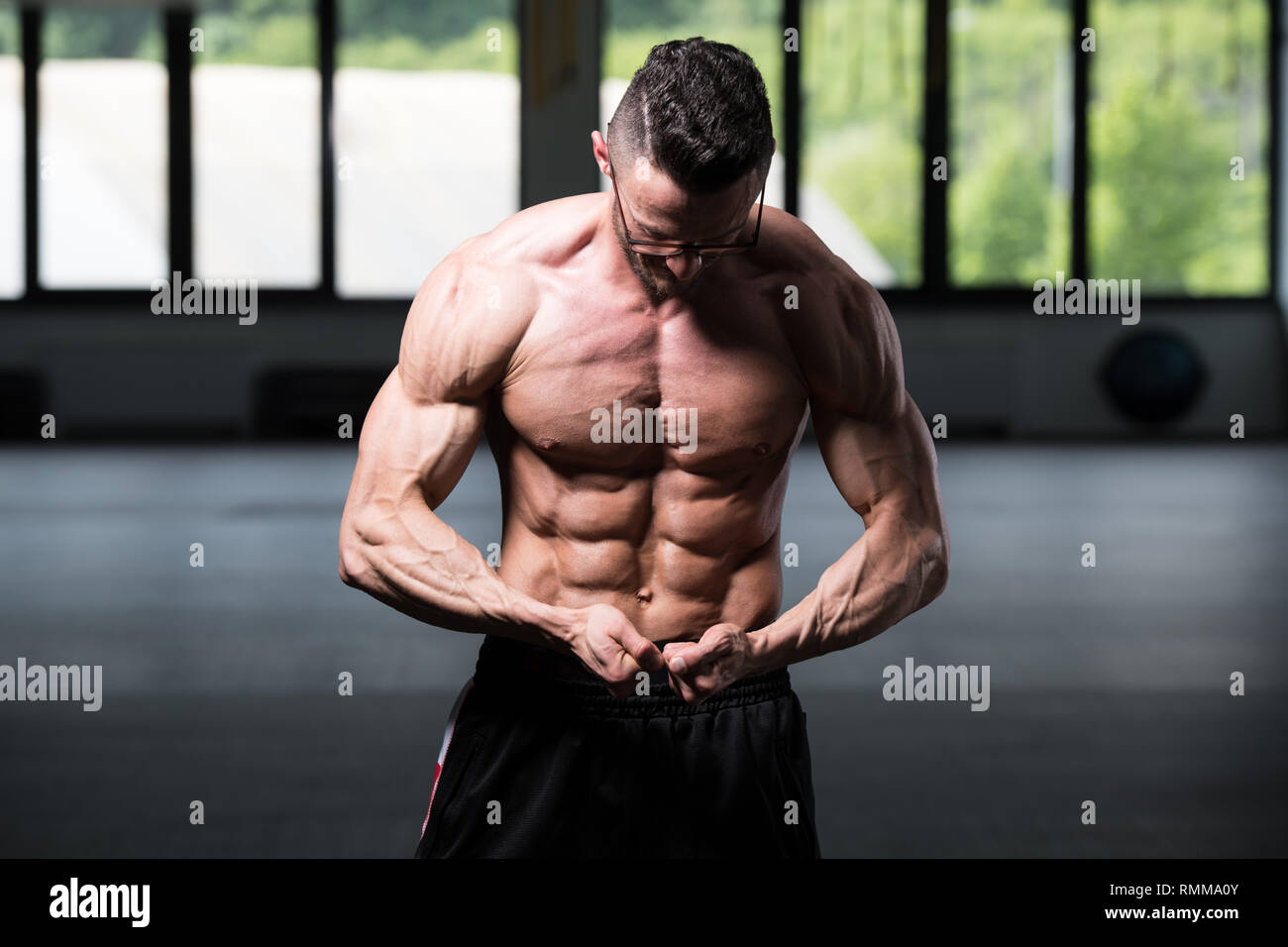 Portrait Of A Young Physically Fit Nerd Man Showing His Well Trained ...