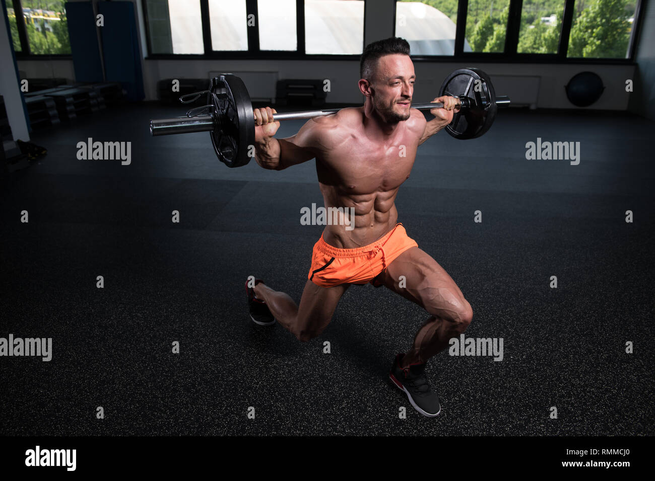 Strong Man In The Gym Exercising Hamstrings With Barbell - Muscular ...