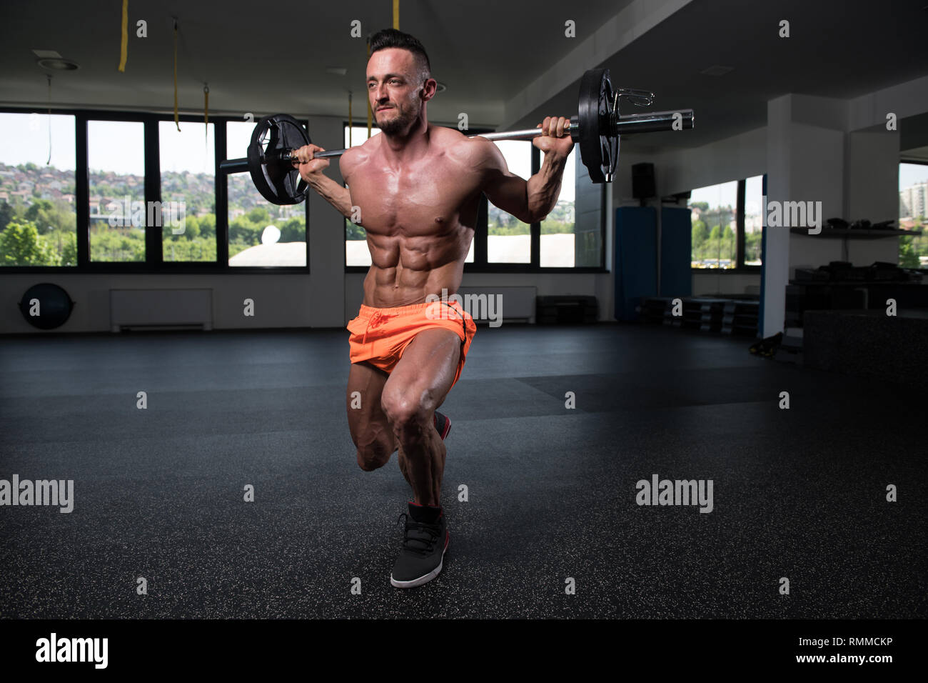 Strong Man In The Gym Exercising Quadriceps And Glutes With Barbell ...