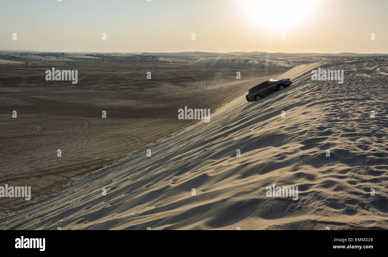 Khor Al Adaid, Qatar - November 5, 2016. 4WD vehicle driving up a sand ...