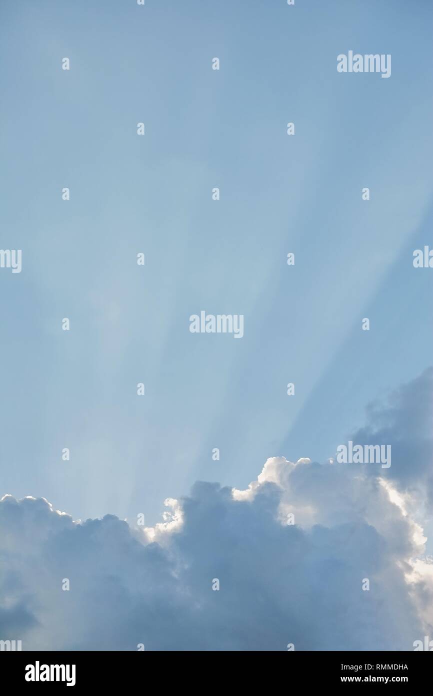 blue sky sun rays from behind the clouds Stock Photo - Alamy