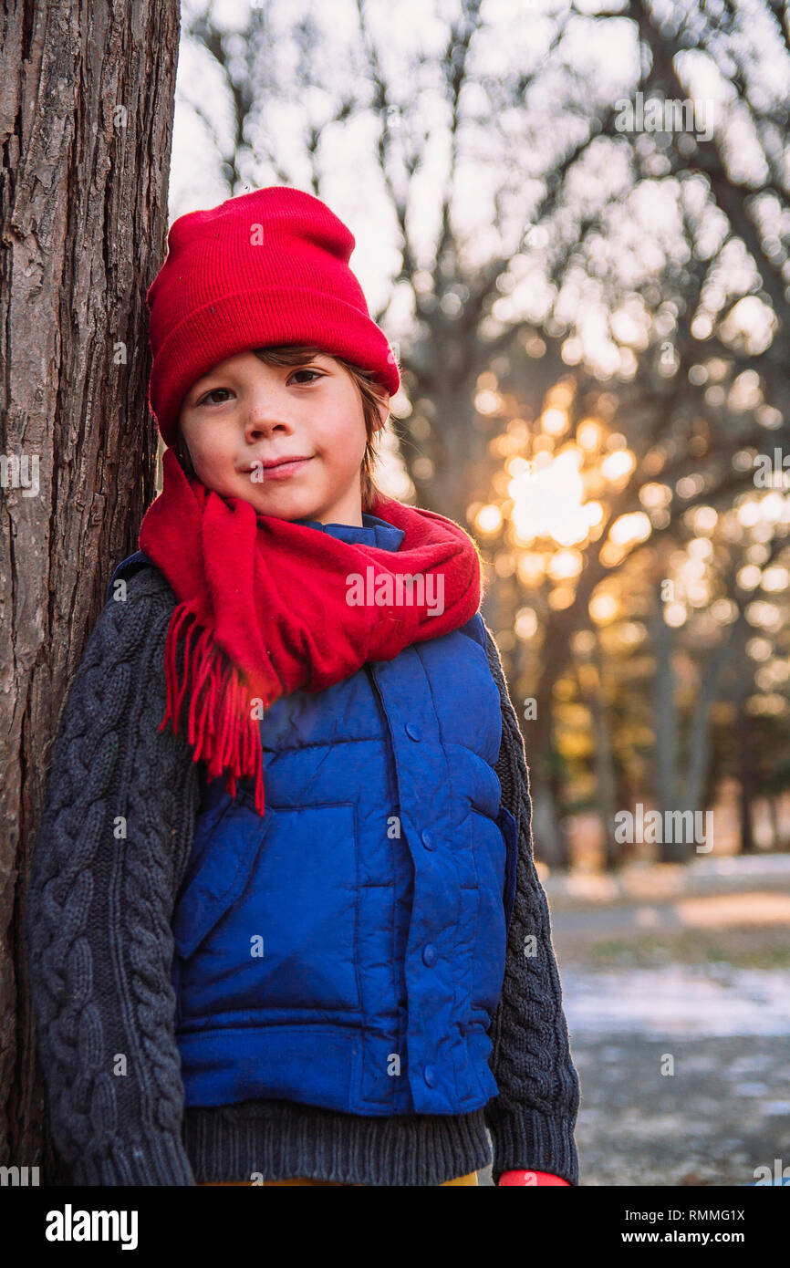 Boy leaning against tree hi-res stock photography and images - Alamy