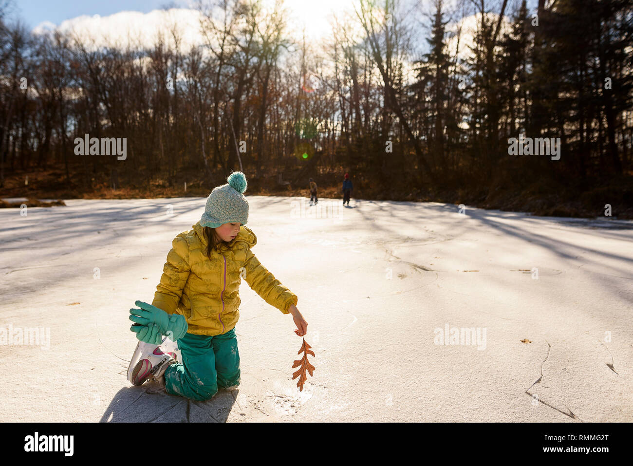 Three children ice-skating on a frozen lake, United States Stock Photo ...