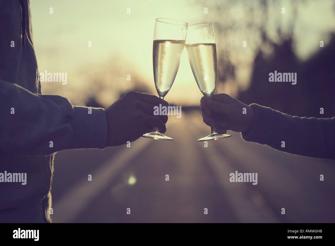 Couple standing outdoors making a celebratory toast Stock Photo - Alamy