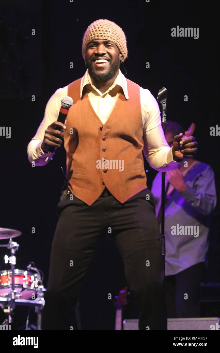 Lead singer Marcus Scott is shown performing on stage during a "live ...