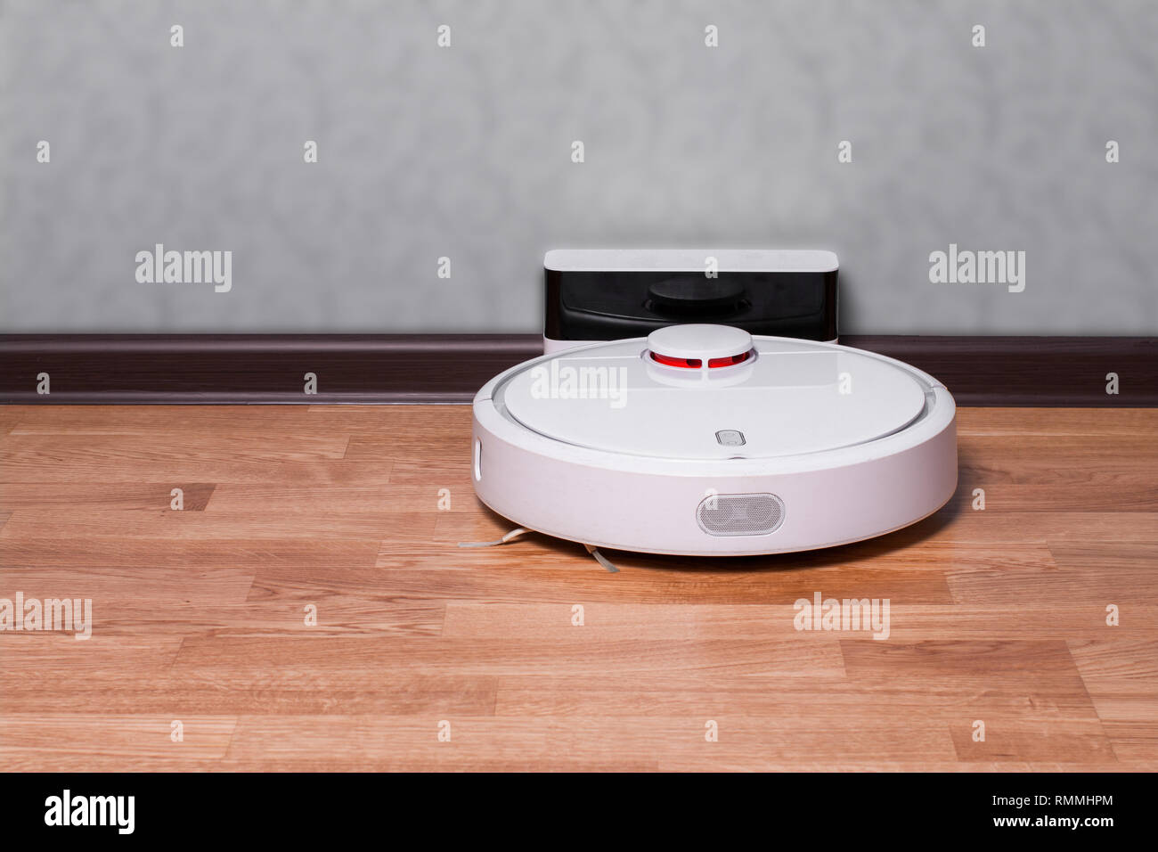 Robot vacuum cleaner on charging dock after it is finished. Modern ...