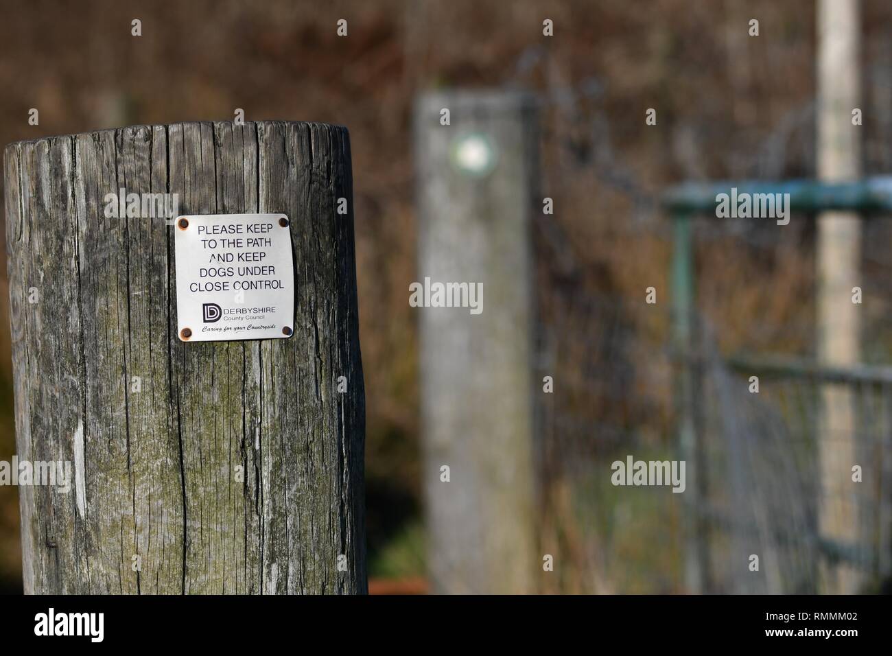 A notice telling walkers to keep to the path and to keep dogs under ...