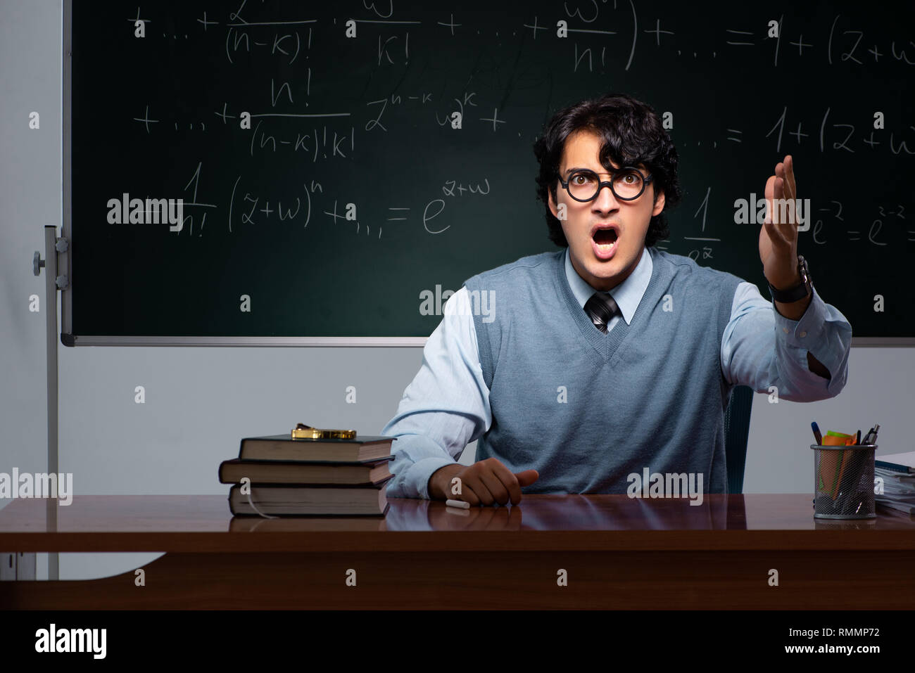Young math teacher in front of chalkboard Stock Photo - Alamy