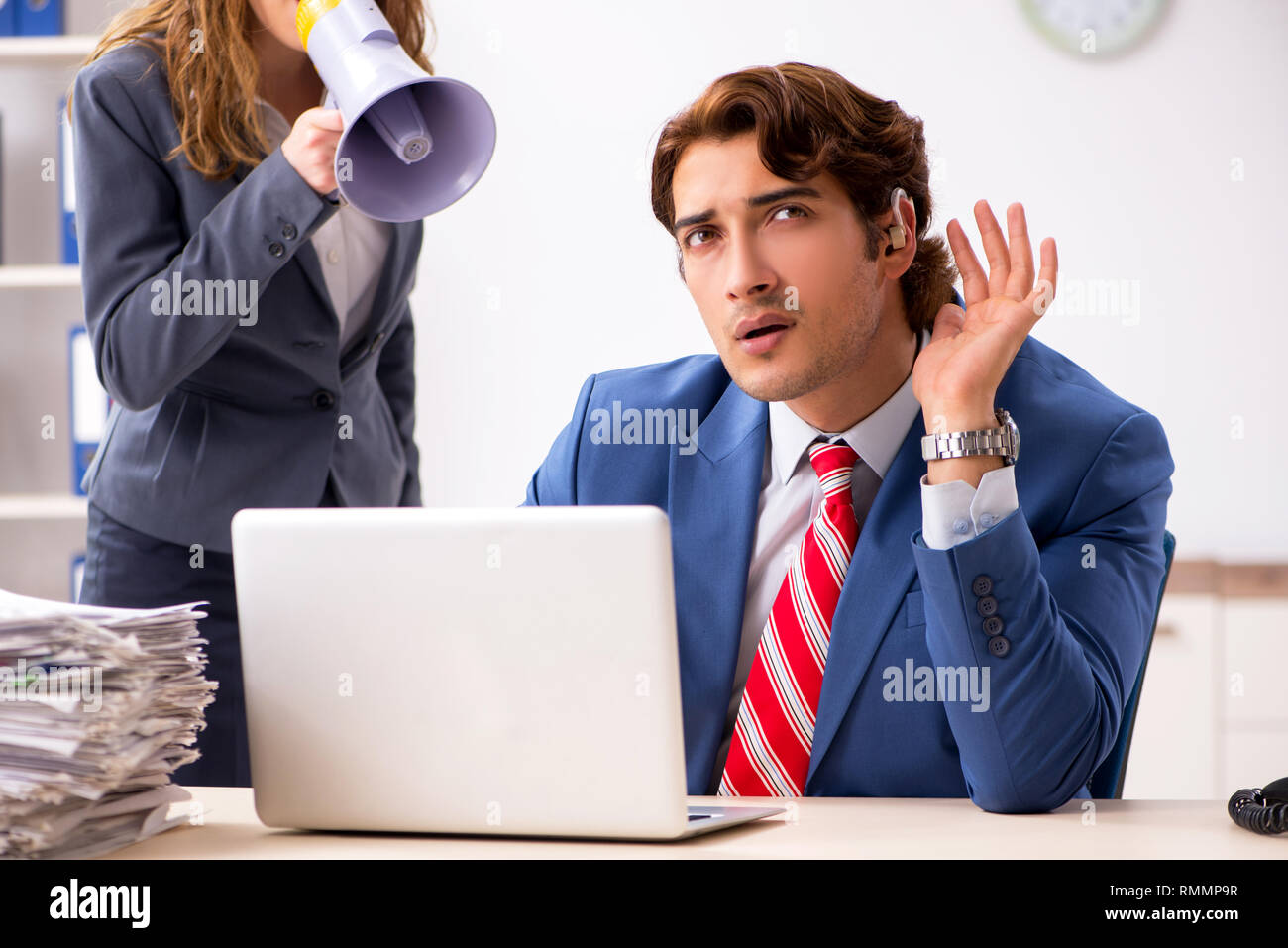 Deaf employee using hearing aid talking to boss Stock Photo - Alamy