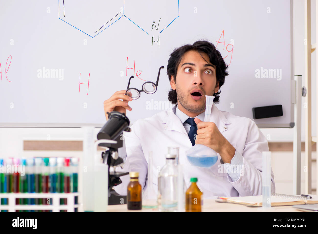 Young funny chemist in front of white board Stock Photo - Alamy